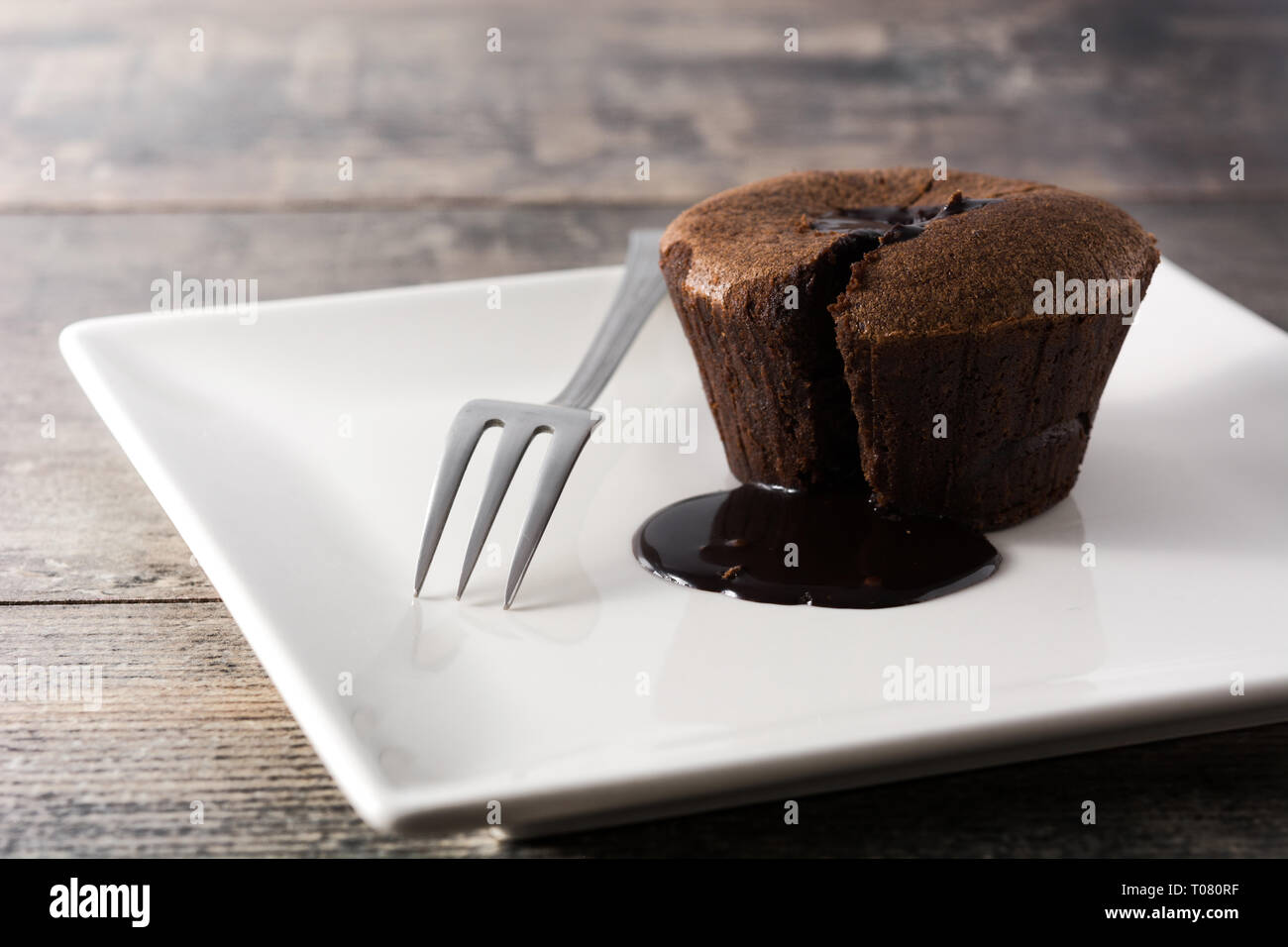Coulant chocolate cake on wooden table Stock Photo - Alamy