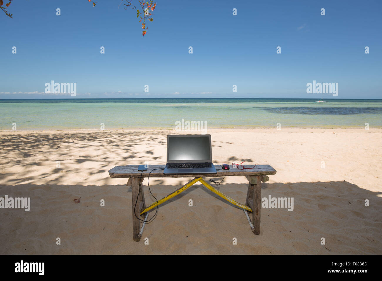 wood bench as desk in a idyllic beach with laptop notebook and mobile ...
