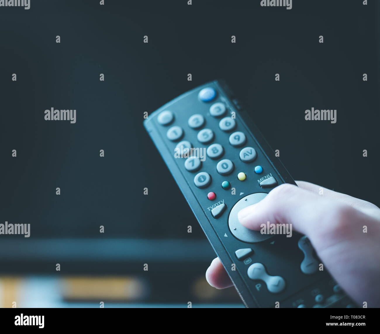 TV remote control in the foreground, tv in the blurry background. Film ...