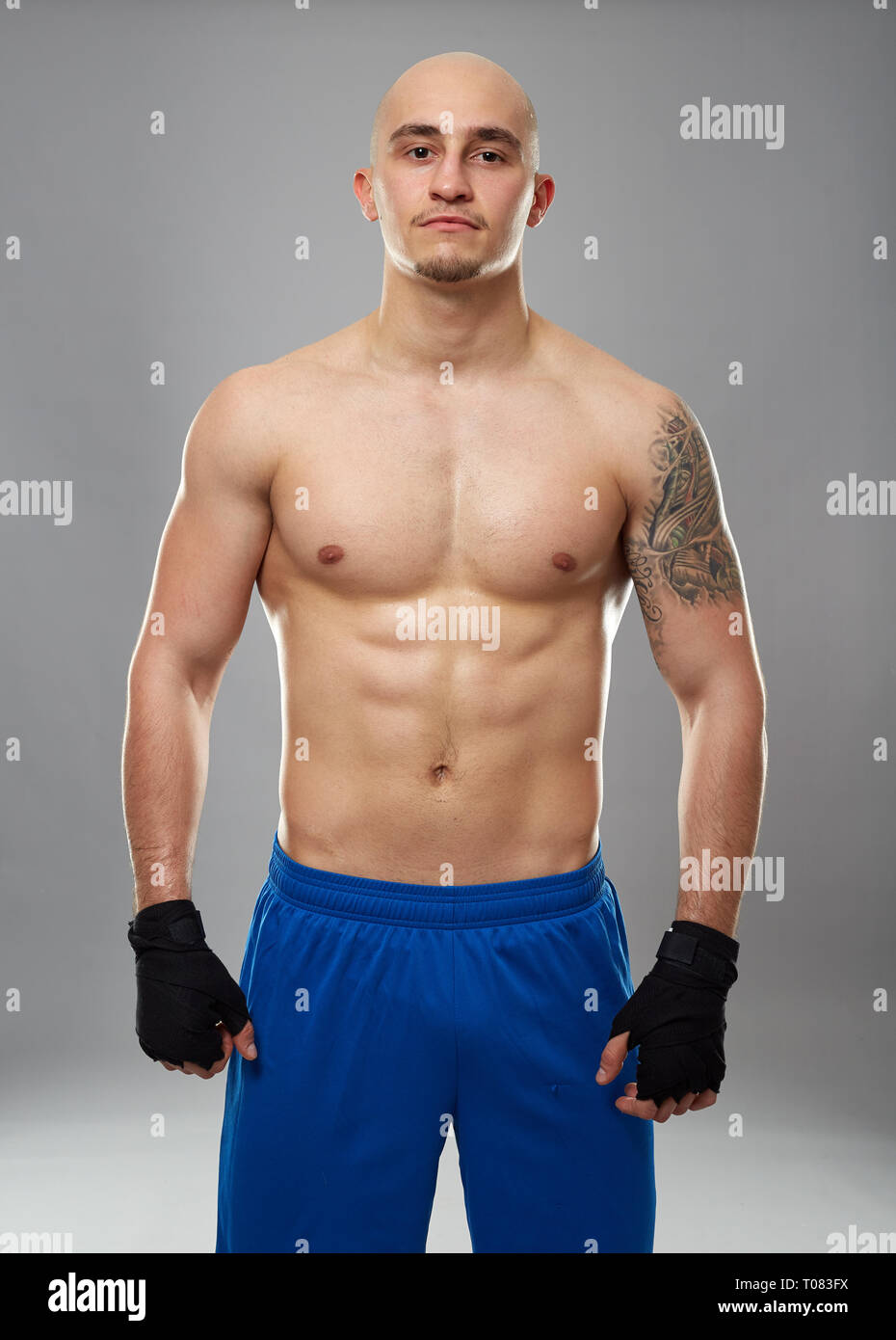 Fighter with hands wrapped posing in studio on gray background Stock ...