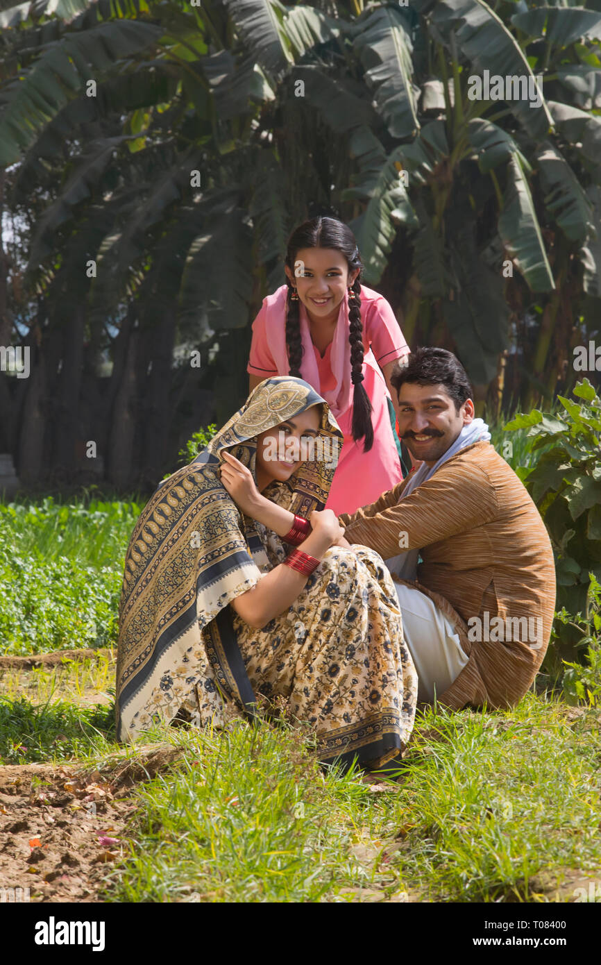 Happy and smiling rural family sitting in their agriculture field Stock ...