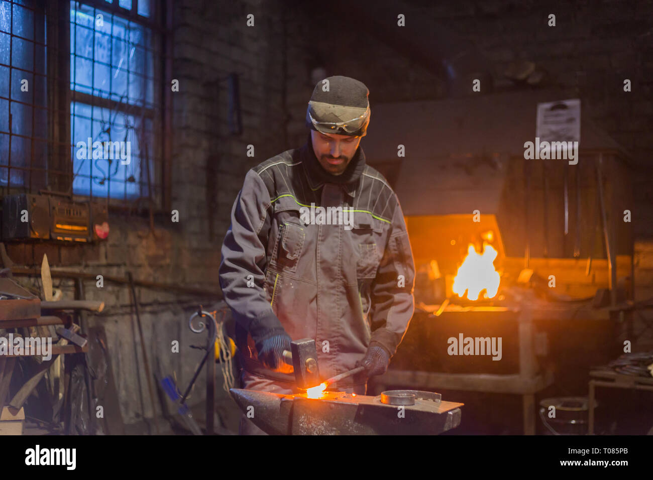 Blacksmith forging molten metal Stock Photo - Alamy