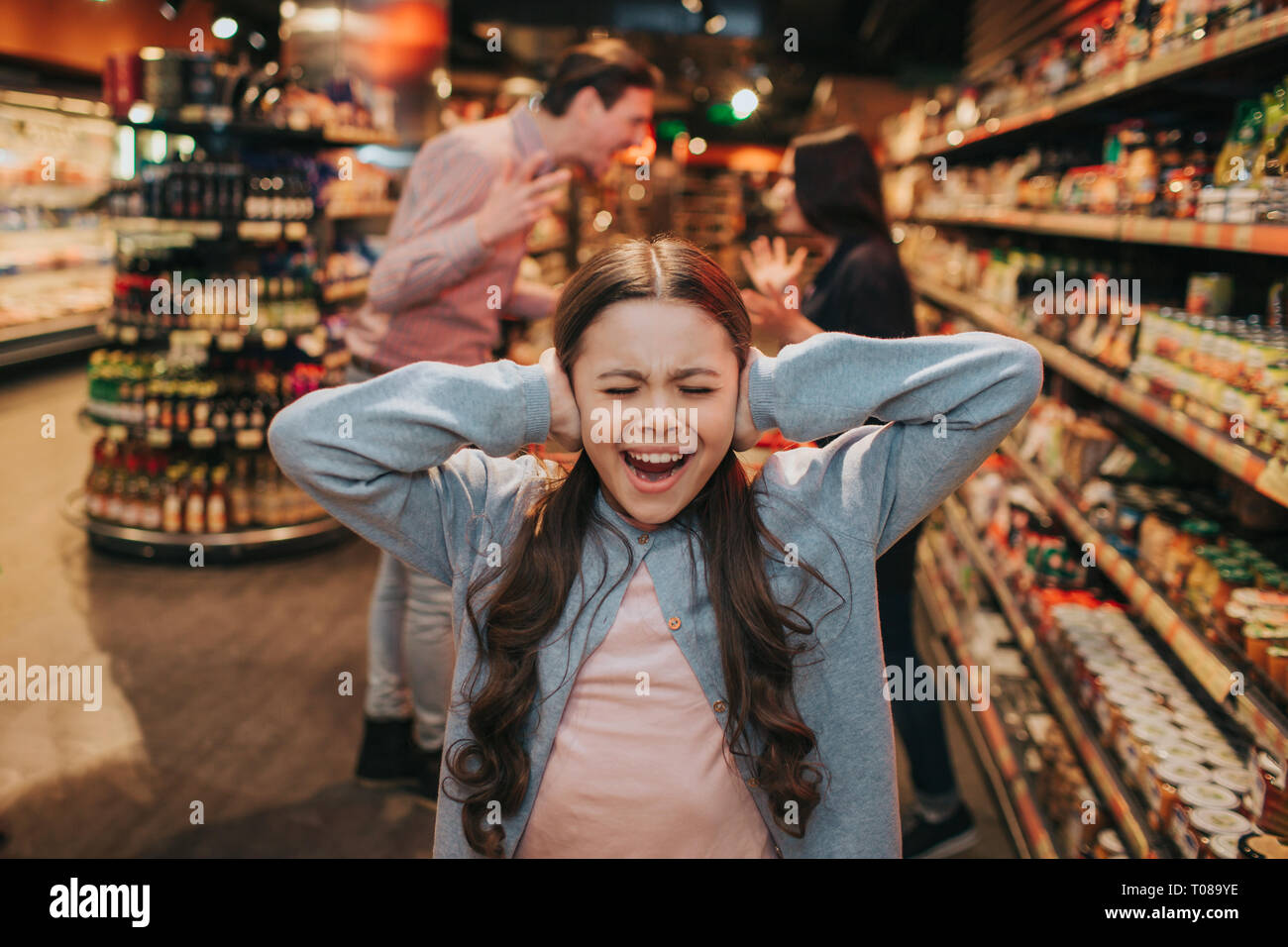 Young parents and daughter in grocery store. Girl screaming and crying ...