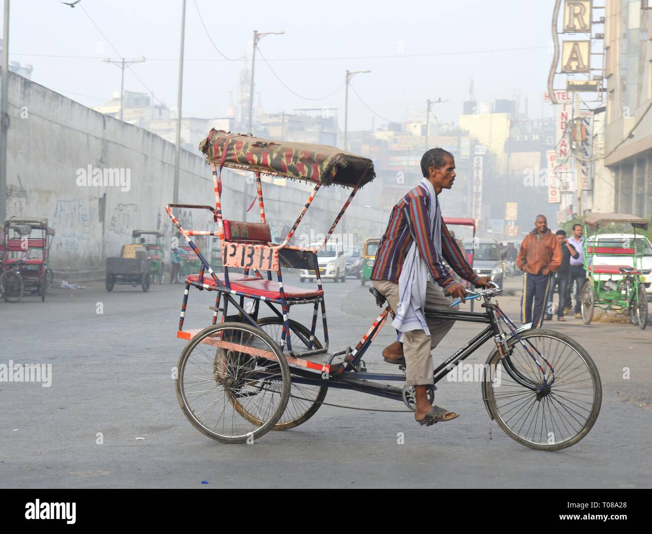 NEW DELHI, INDIA—MARCH 2018: A cycle rickshaw driver waits pedals ...