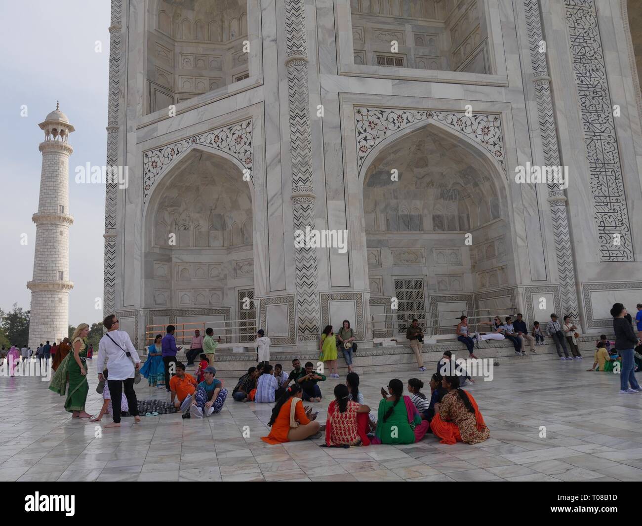 AGRA, UTTAR PRADESH, INDIA--MARCH 2018: People sit on the marble floors ...