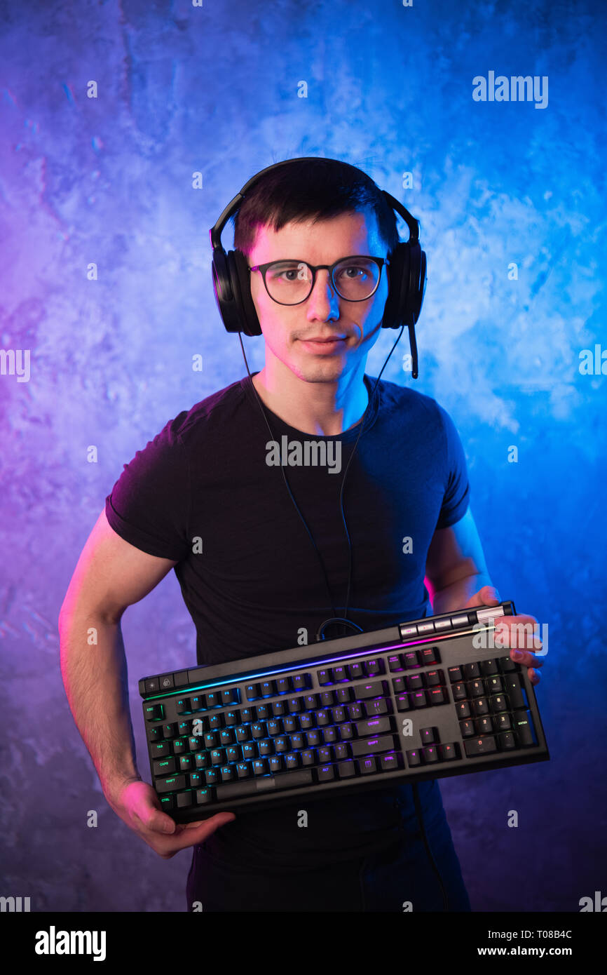 Professional Boy Gamer holding gaming keyboard over colorful pink and ...