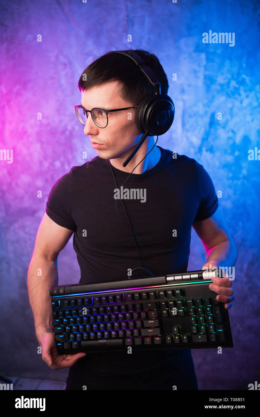 Professional Boy Gamer holding gaming keyboard over colorful pink and ...