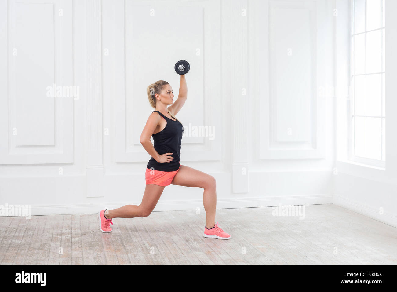 Side view portrait of young athletic beautiful bodybuilder woman in ...