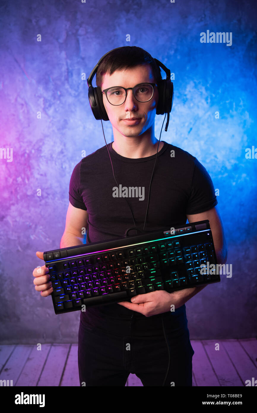 Professional Boy Gamer holding gaming keyboard over colorful pink and ...