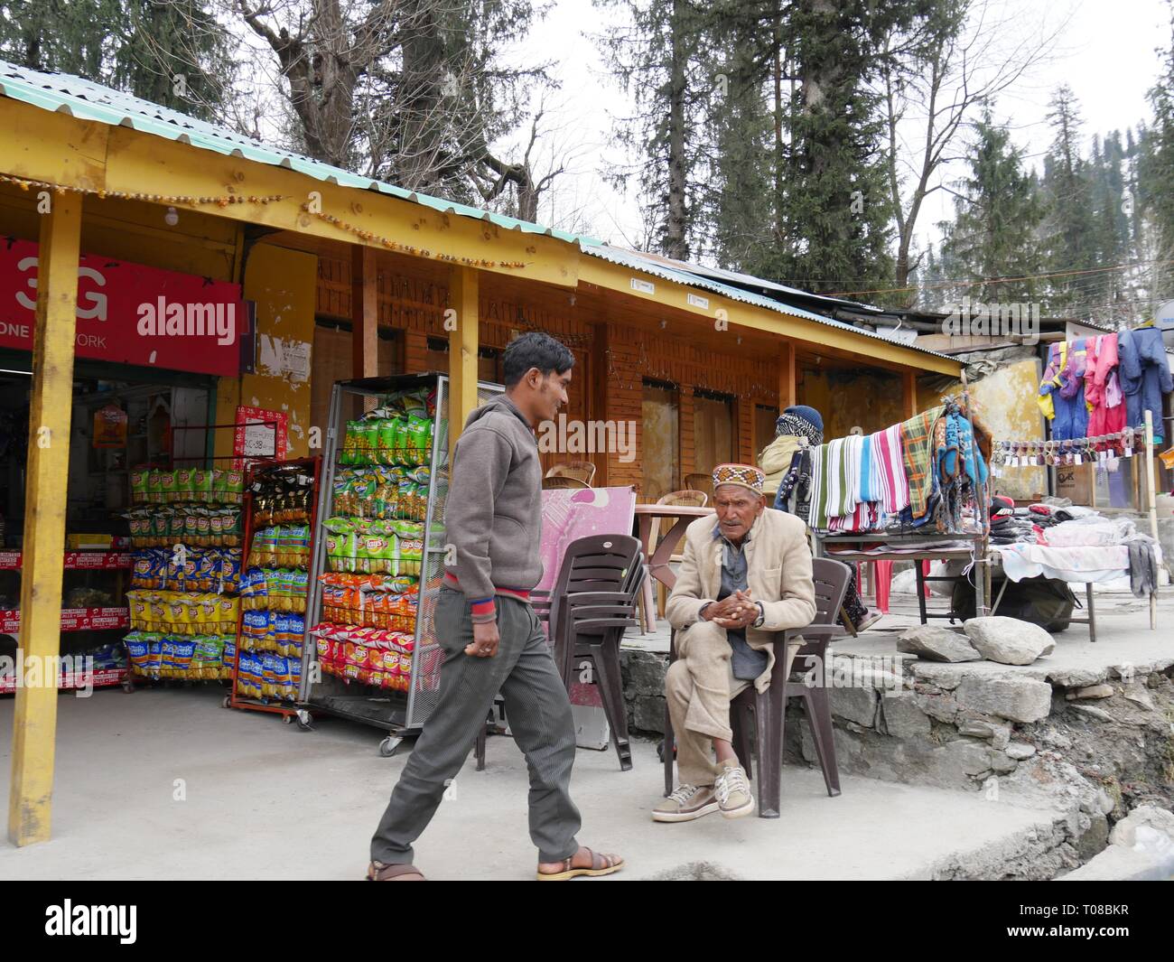 SOLANG VALLEY, HIMACHAL PRADESH—MARCH 2018: A man sits outside a snack store in Solang Valley ...