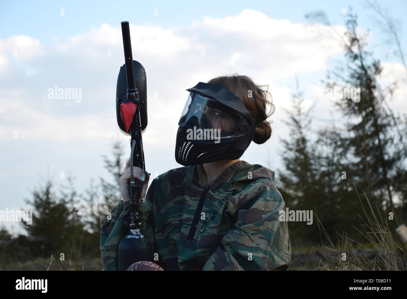 Paintball sport player girl in protective camouflage uniform and mask ...