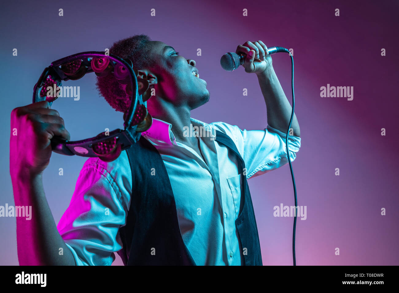 African American handsome jazz musician playing tambourine and singing ...
