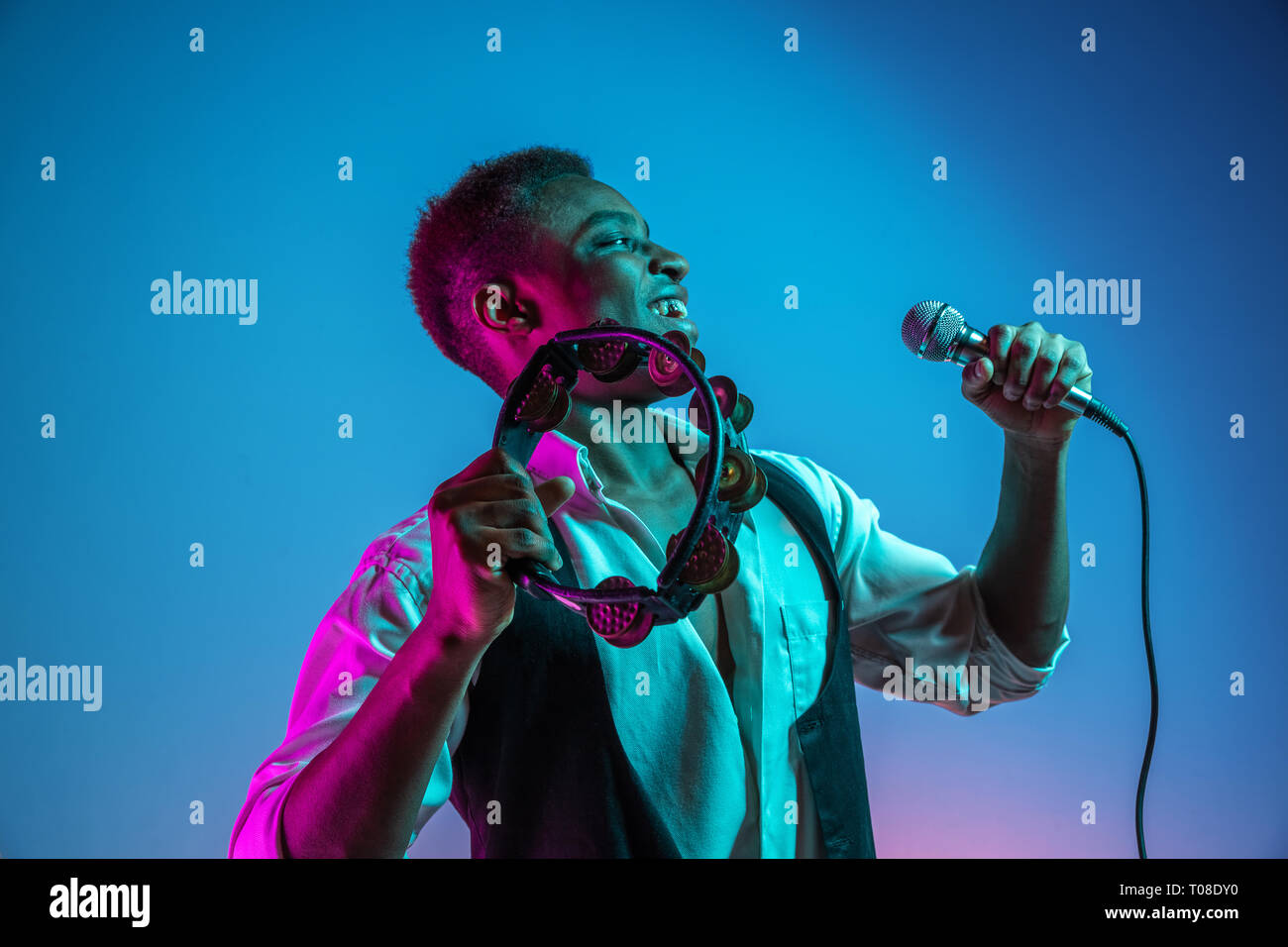African American handsome jazz musician playing tambourine and singing ...