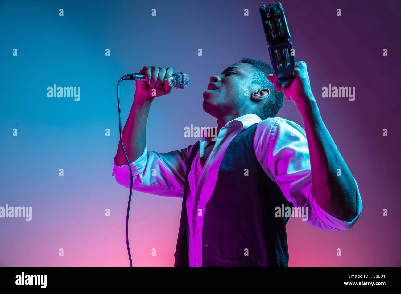 African American handsome jazz musician playing tambourine and singing ...