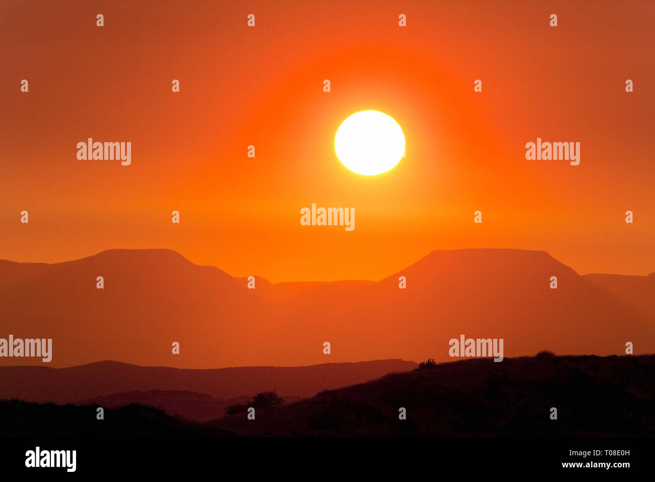 Africa, Namibia, Damaraland. Dramatic sunset caused by atmospheric dust ...