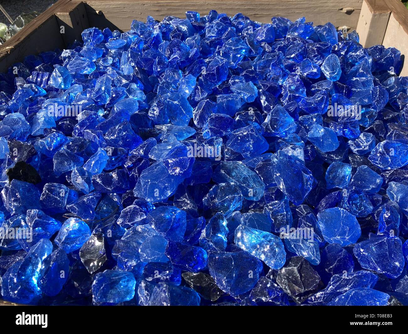 Pile of blue glass rock in a crate Stock Photo - Alamy