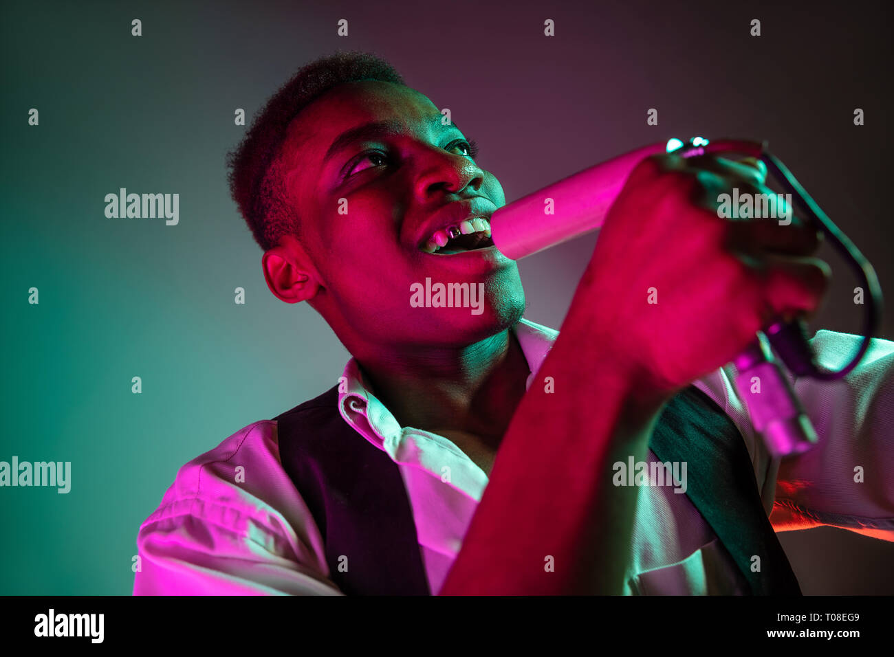 African American handsome jazz musician singing into the microphone in ...