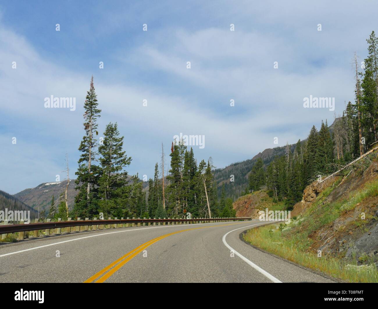 Wide shot of a scenic drive from the east entrance of Yellowstone ...