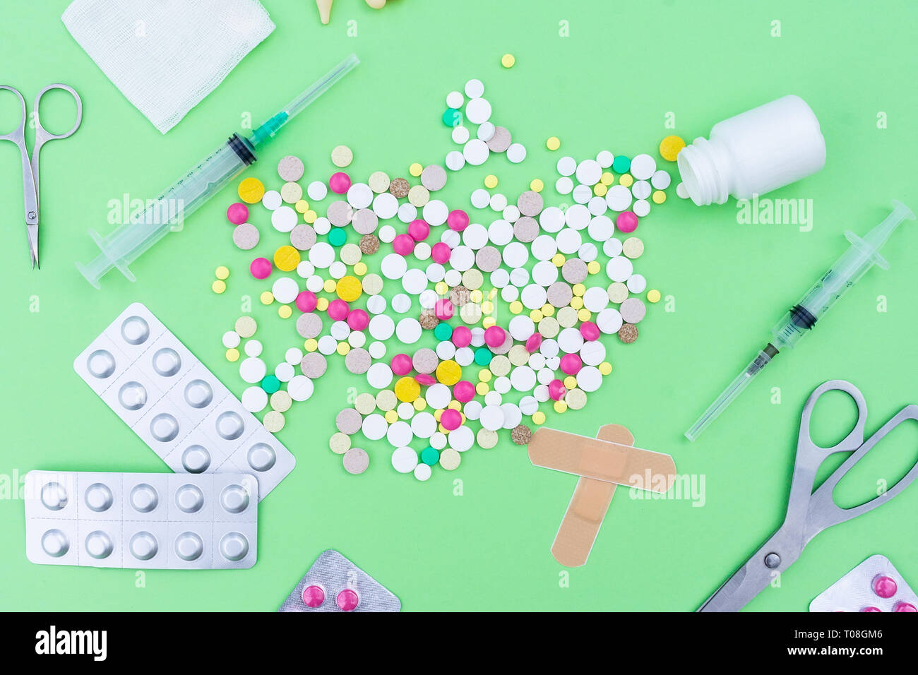 Assorted pharmaceutical medicine pills, tablets and capsules over green ...