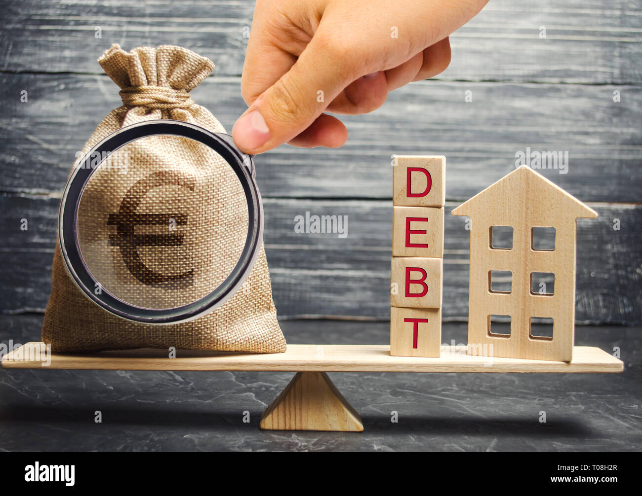 Money bag and wooden blocks with the word Debt and a miniature house on ...