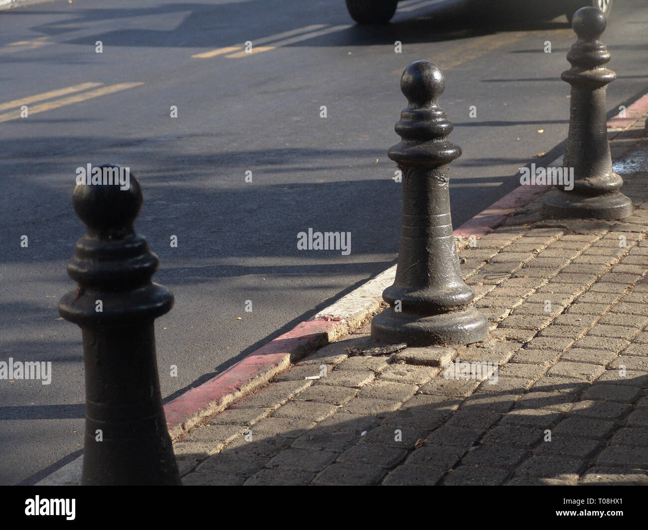 Three metal posts on a paved sidewalk urban view in daylight Stock ...