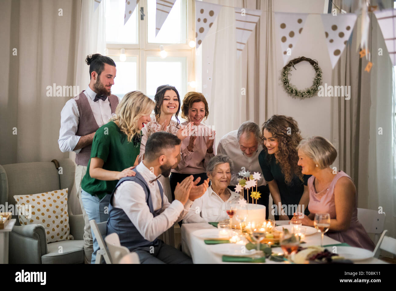 An elderly woman with multigeneration family celebrating birthday on ...
