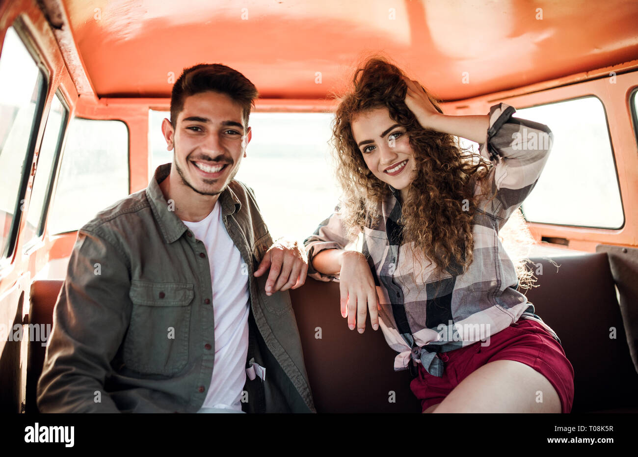 A young couple on a roadtrip through countryside, driving minivan Stock ...