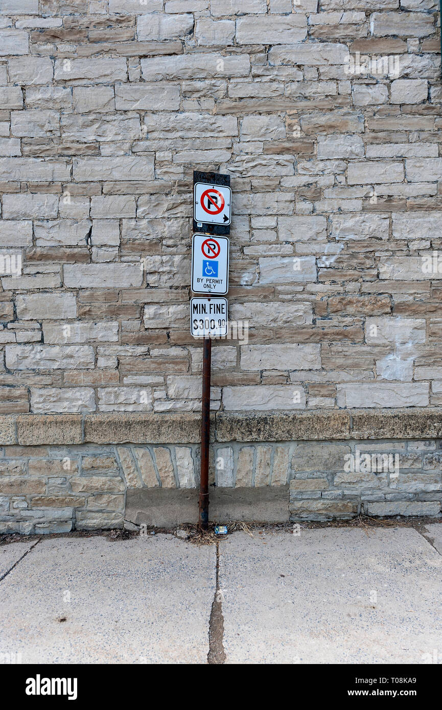 Parking rules on a sign post next to the stone wall of a building Stock ...