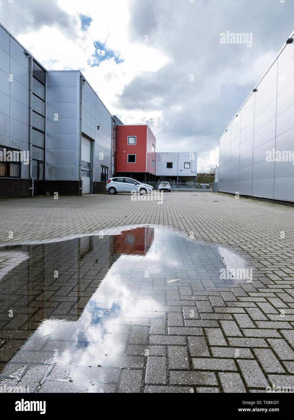 buildings in industrial area with puddle after rain and cars Stock ...