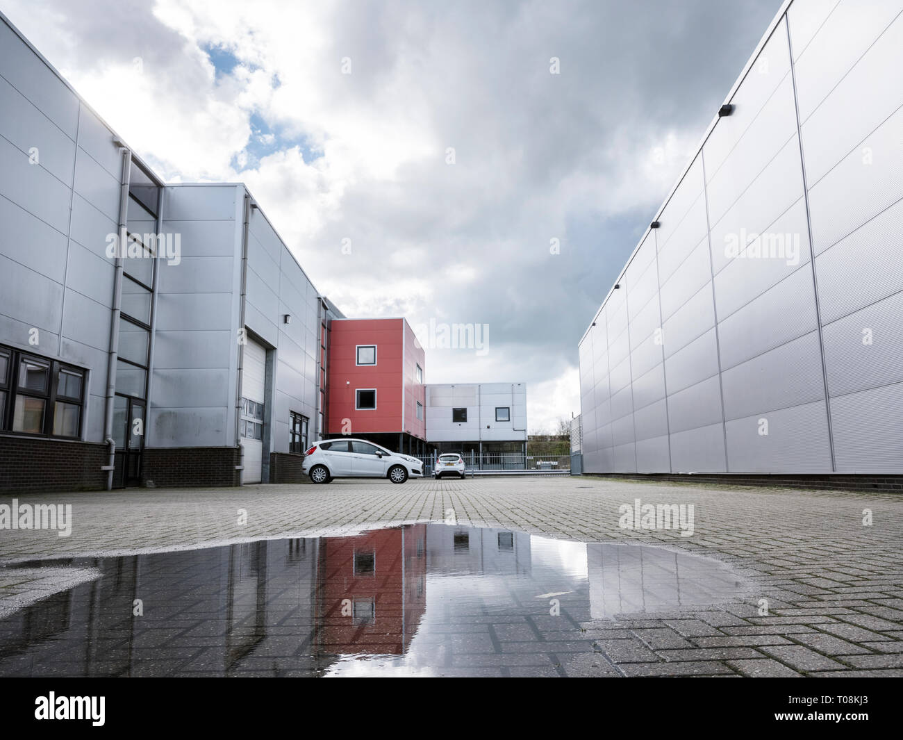 buildings in industrial area with puddle after rain and cars Stock ...