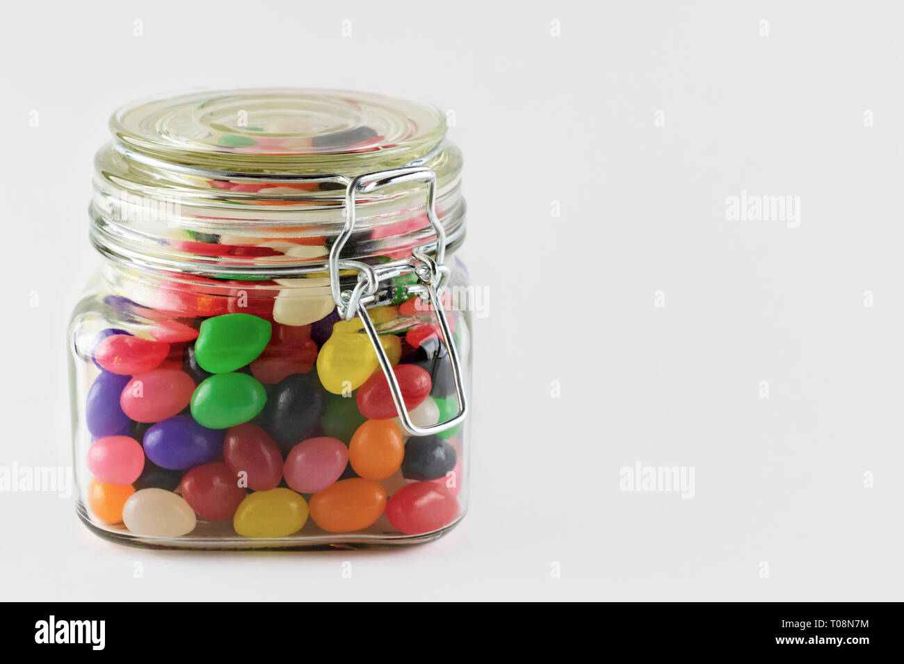 An assortment of jelly beans in a glass jar with clasp lid. Isolated on ...