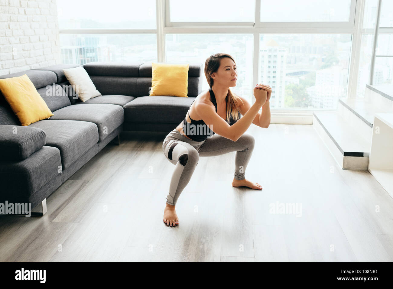 Adult Woman Training Legs Doing In and Out Squat Stock Photo - Alamy
