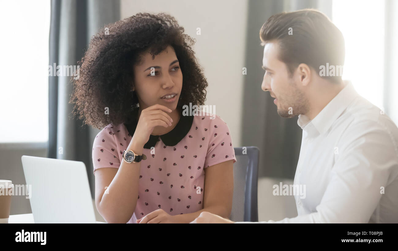 Diverse colleagues talk in office working with laptop share ideas Stock ...