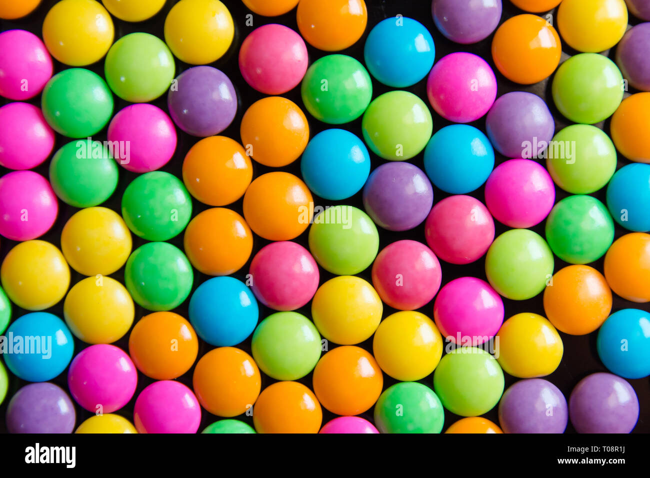 Pile of colorful sweet candy chocolates coated background. colourful ...