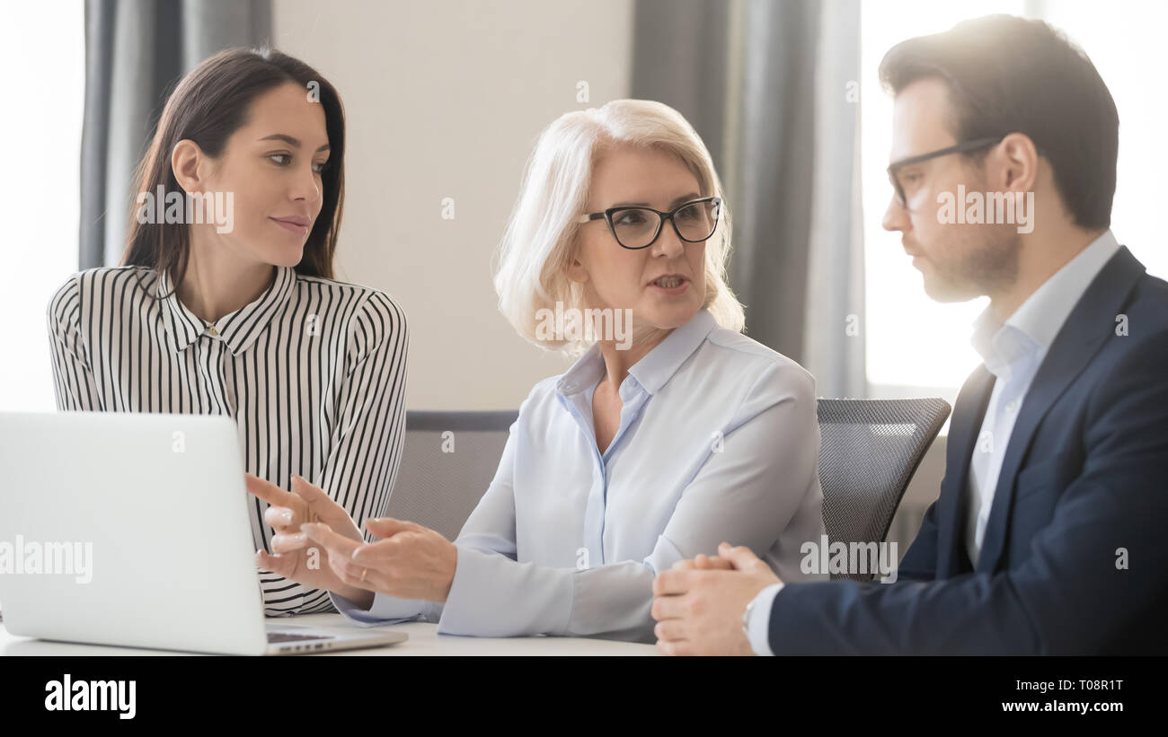 Old female leader speaking mentoring with computer at group meeting ...