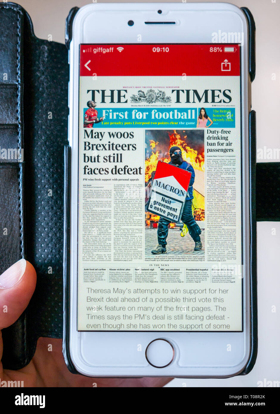 Hand holding mobile phone screen showing BBC News app with front cover ...