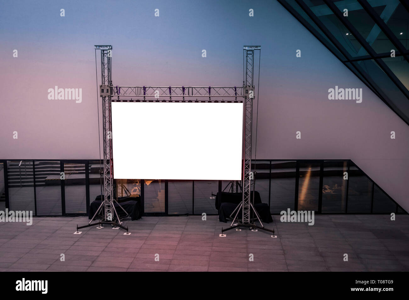 Mock up. Rectangle blank temporary display screen outside near modern ...