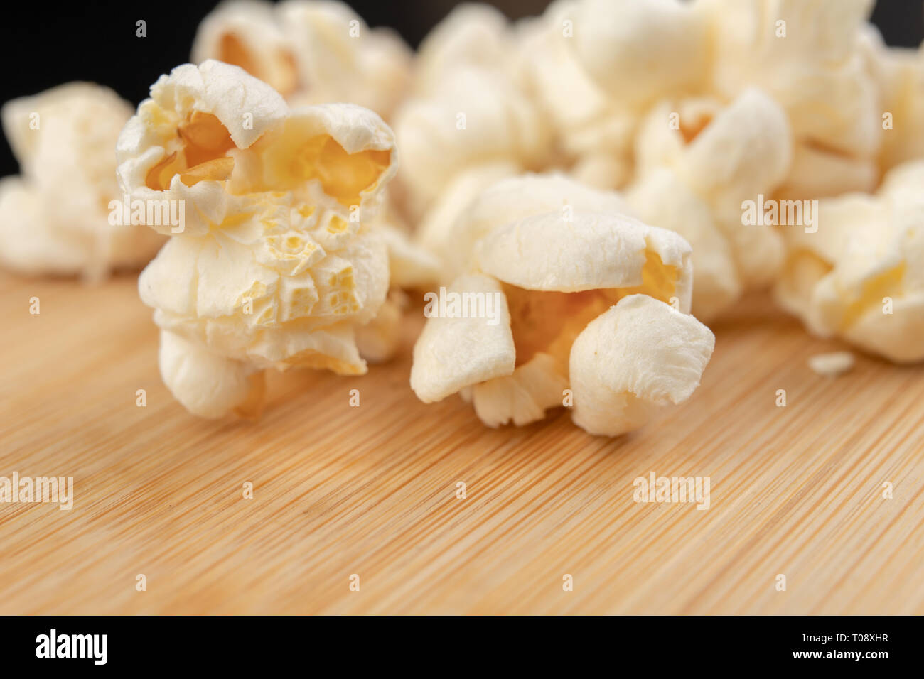 Popcorn on the kitchen table. Delicious roasted corn kernels. Light ...