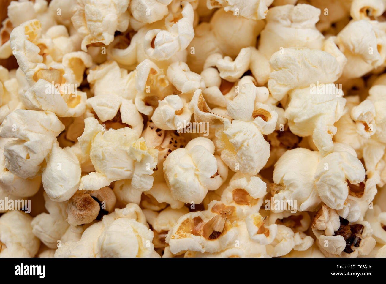 Popcorn on the kitchen table. Delicious roasted corn kernels. Light ...