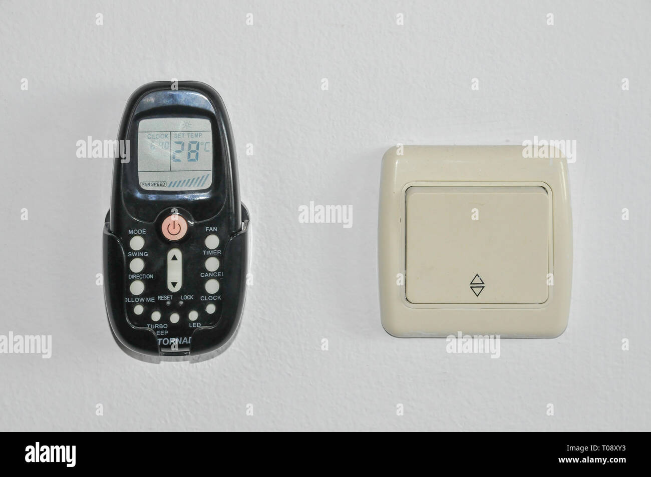 Airconditioner remote control and light switch on white background ...
