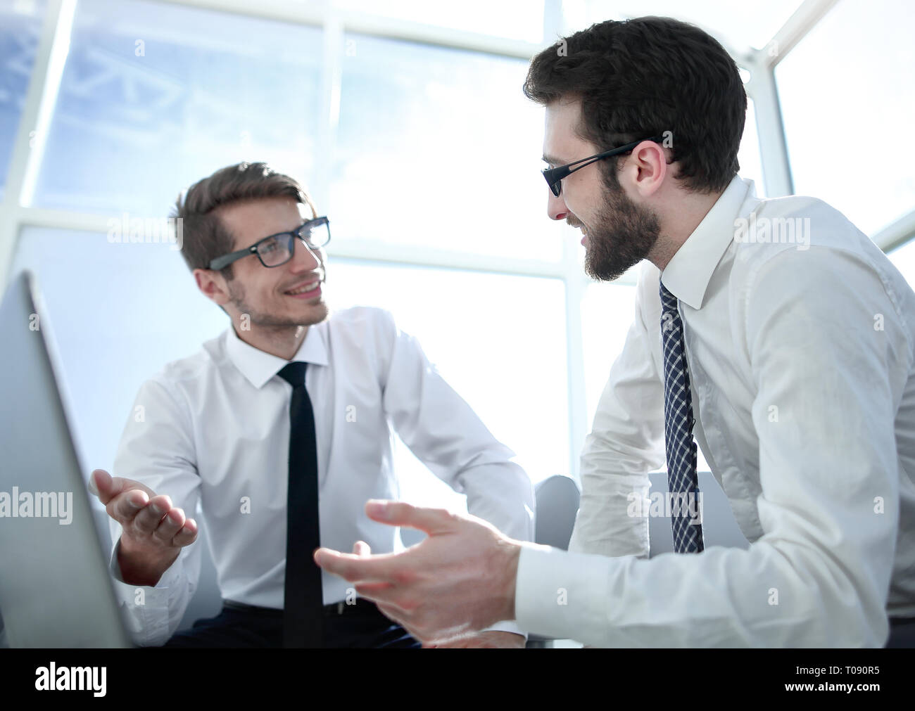employees discuss something sitting in front of an open laptop Stock ...