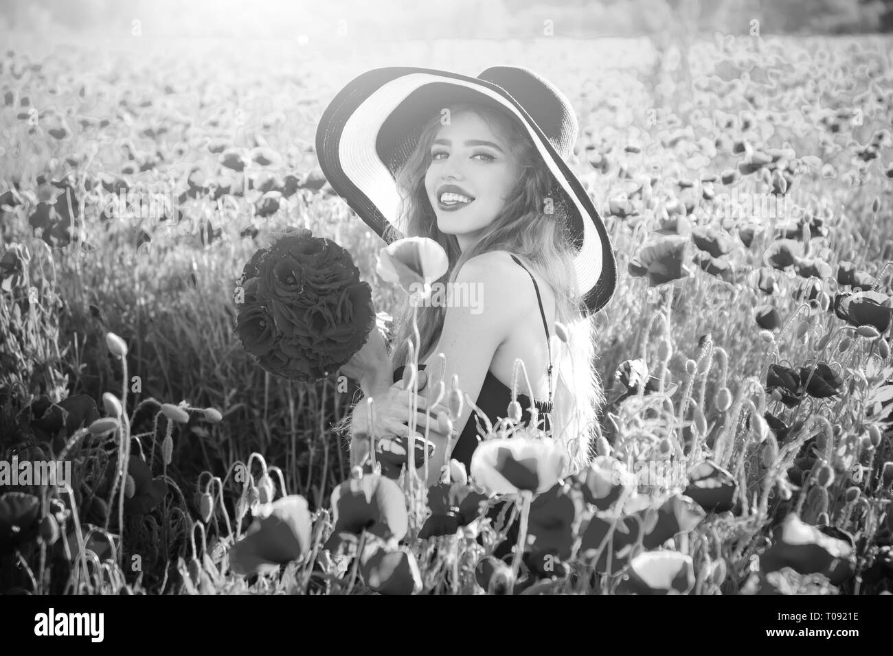 beautiful smiling girl with hat in red poppy field Stock Photo - Alamy