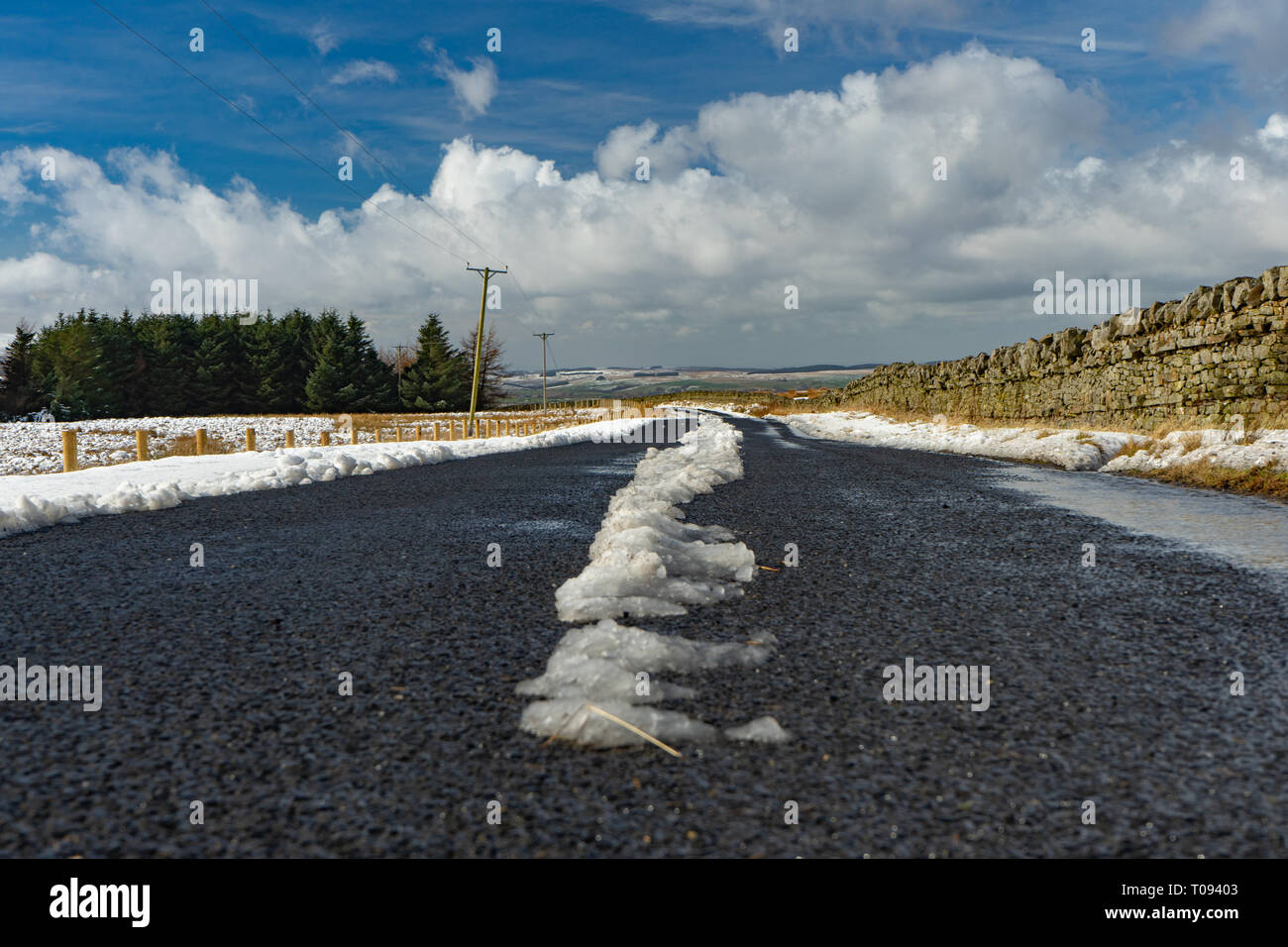 snow melting from rural road Stock Photo - Alamy