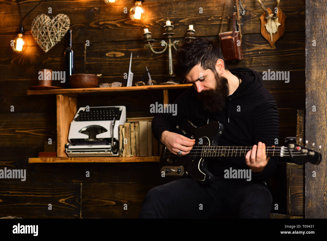 Soul music. Man bearded musician enjoy evening with bass guitar, wooden ...