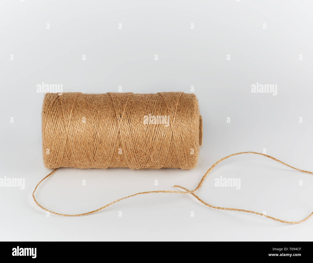spool-wrapped brown rope of jute, white background Stock Photo - Alamy