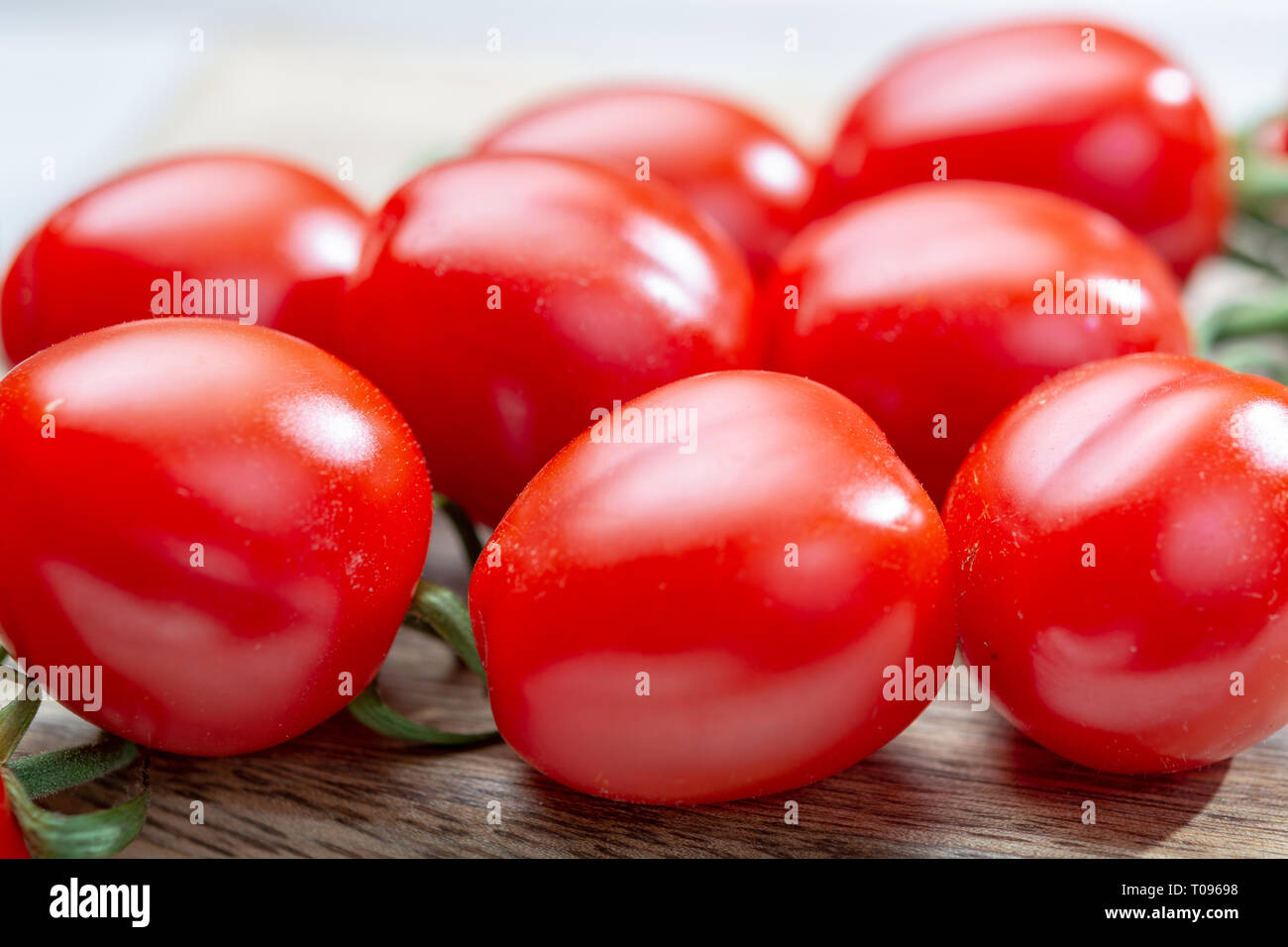 Vine of fresh ripe red cherry prunella tomates close up Stock Photo - Alamy