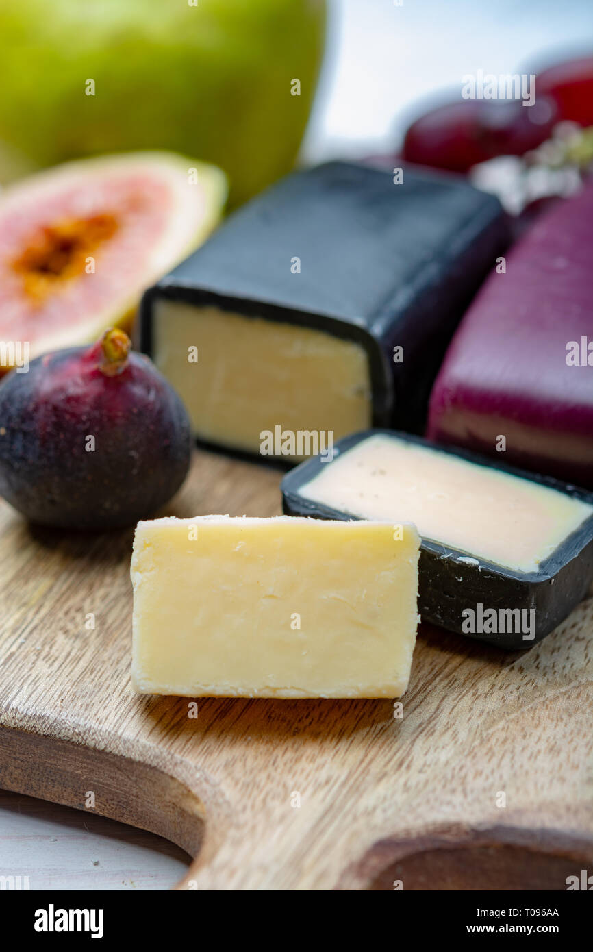 Mini black and dark red waxed cheddar cheeses made from West Country ...