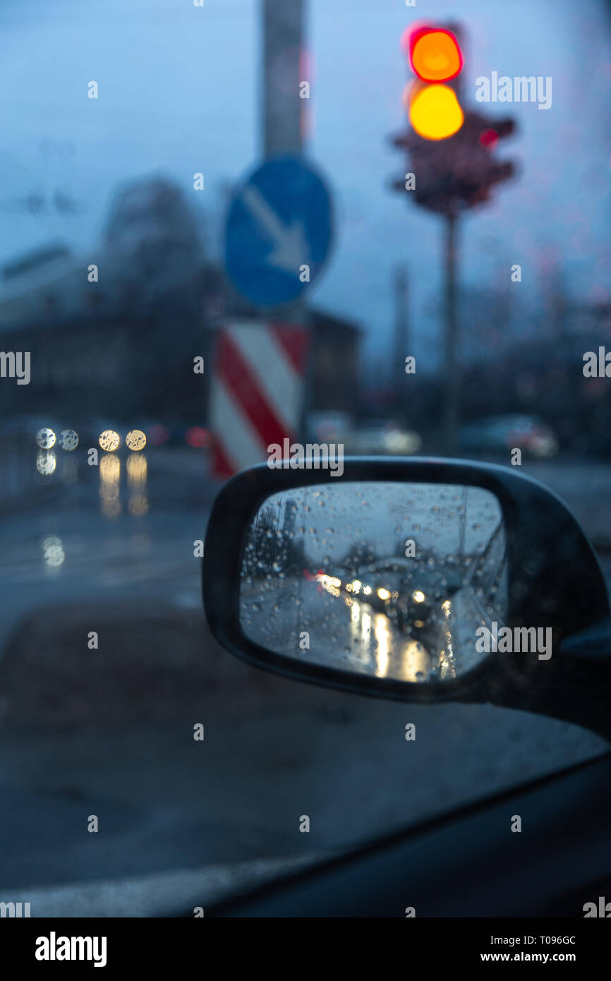 Evening traffic jam in side rear-view mirror with red and yellow ...