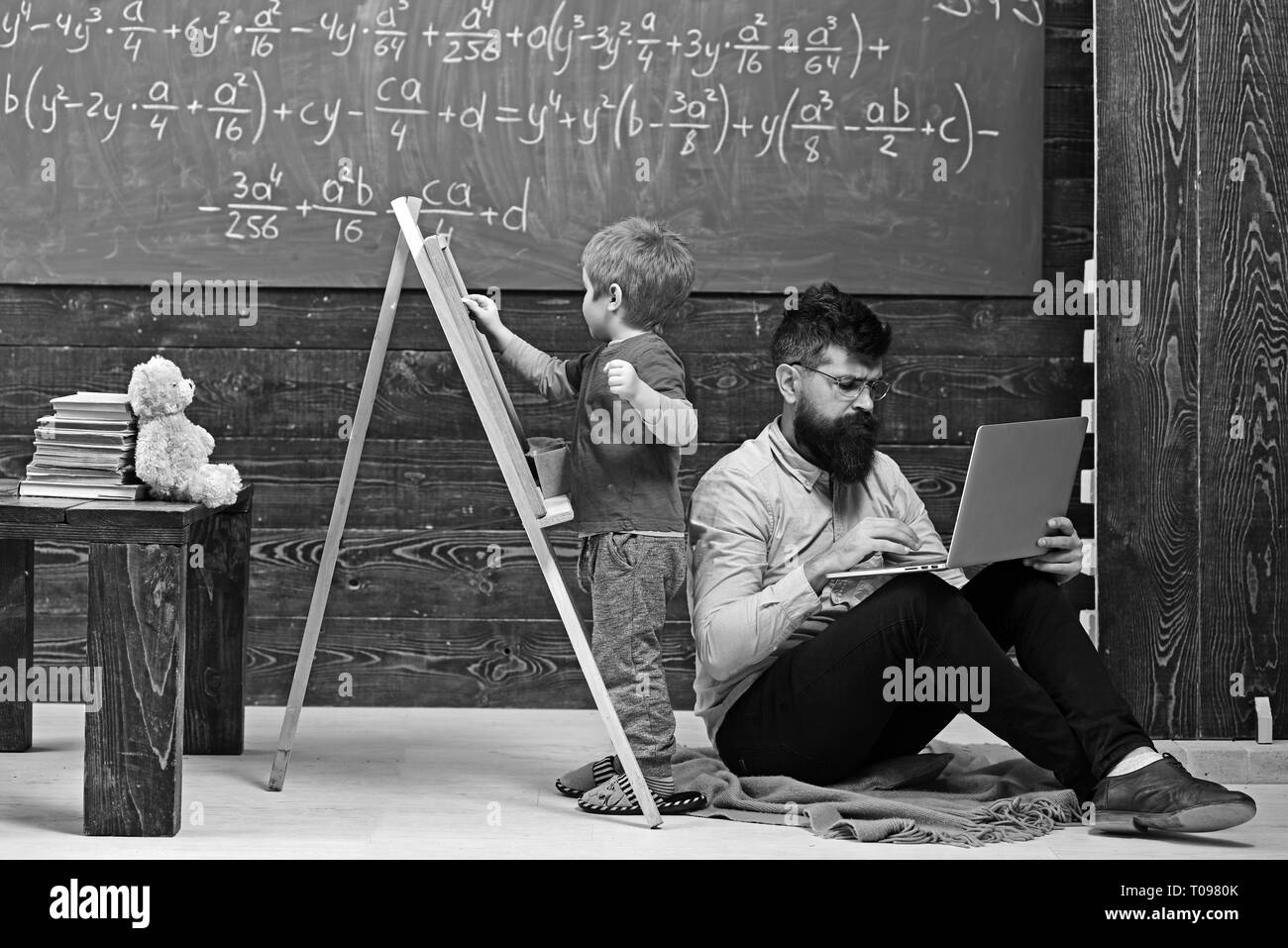 Arithmetic lesson at school. Kid writing on chalkboard while ...