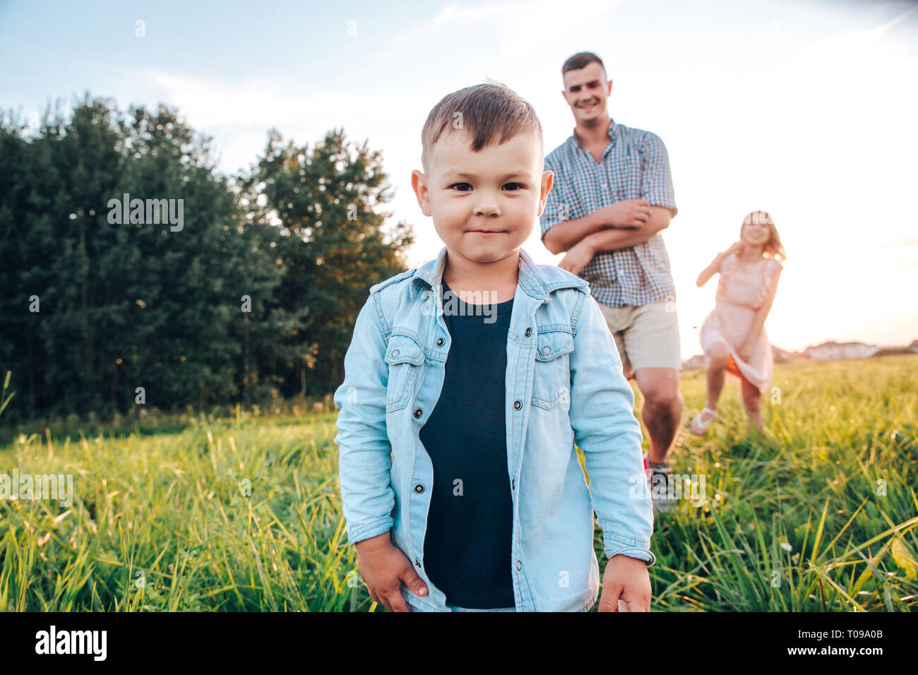 Happy little boy with parents walking in field . Happy family concept ...
